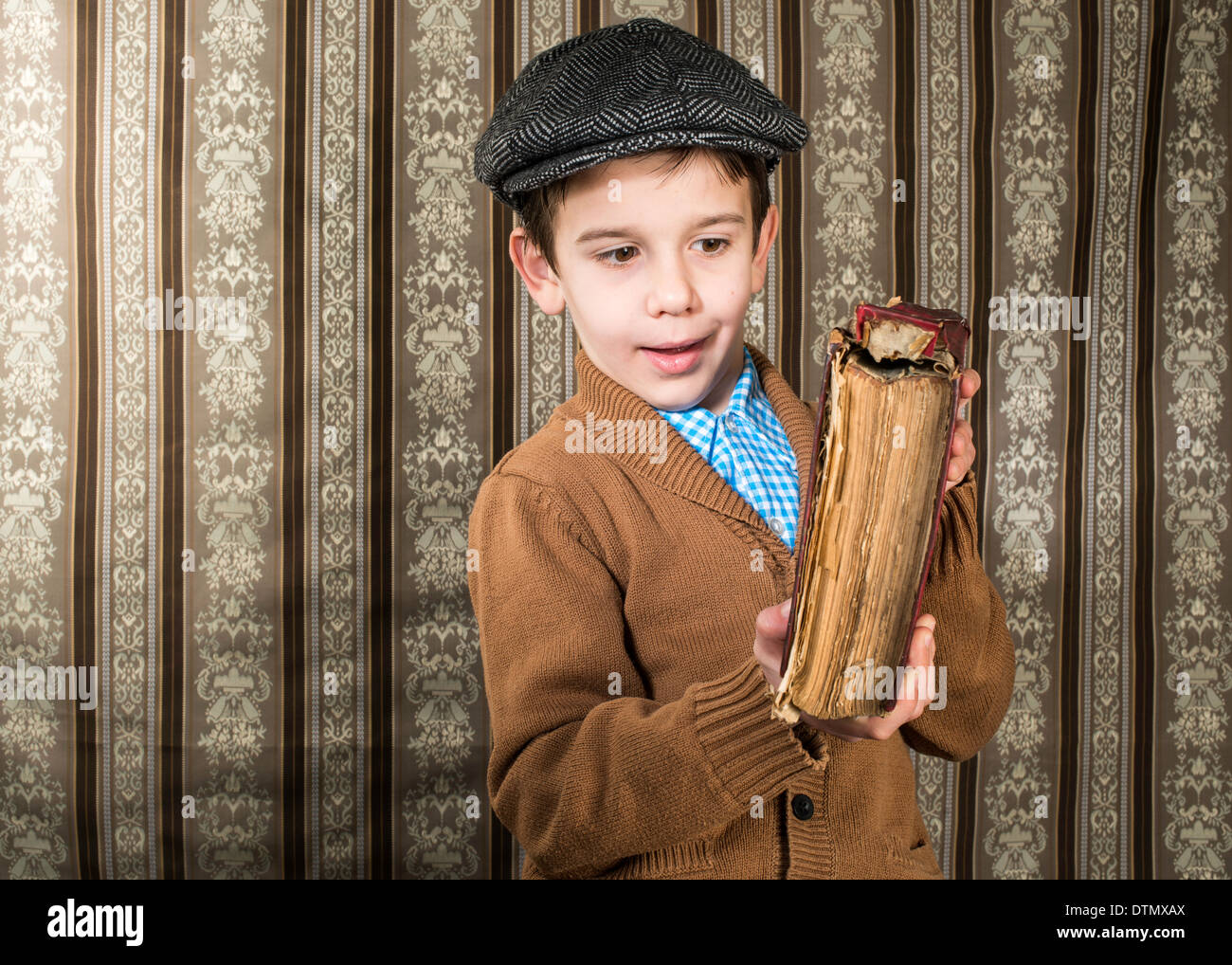 Child with red vintage book. Vintage clothes and hat Stock Photo - Alamy
