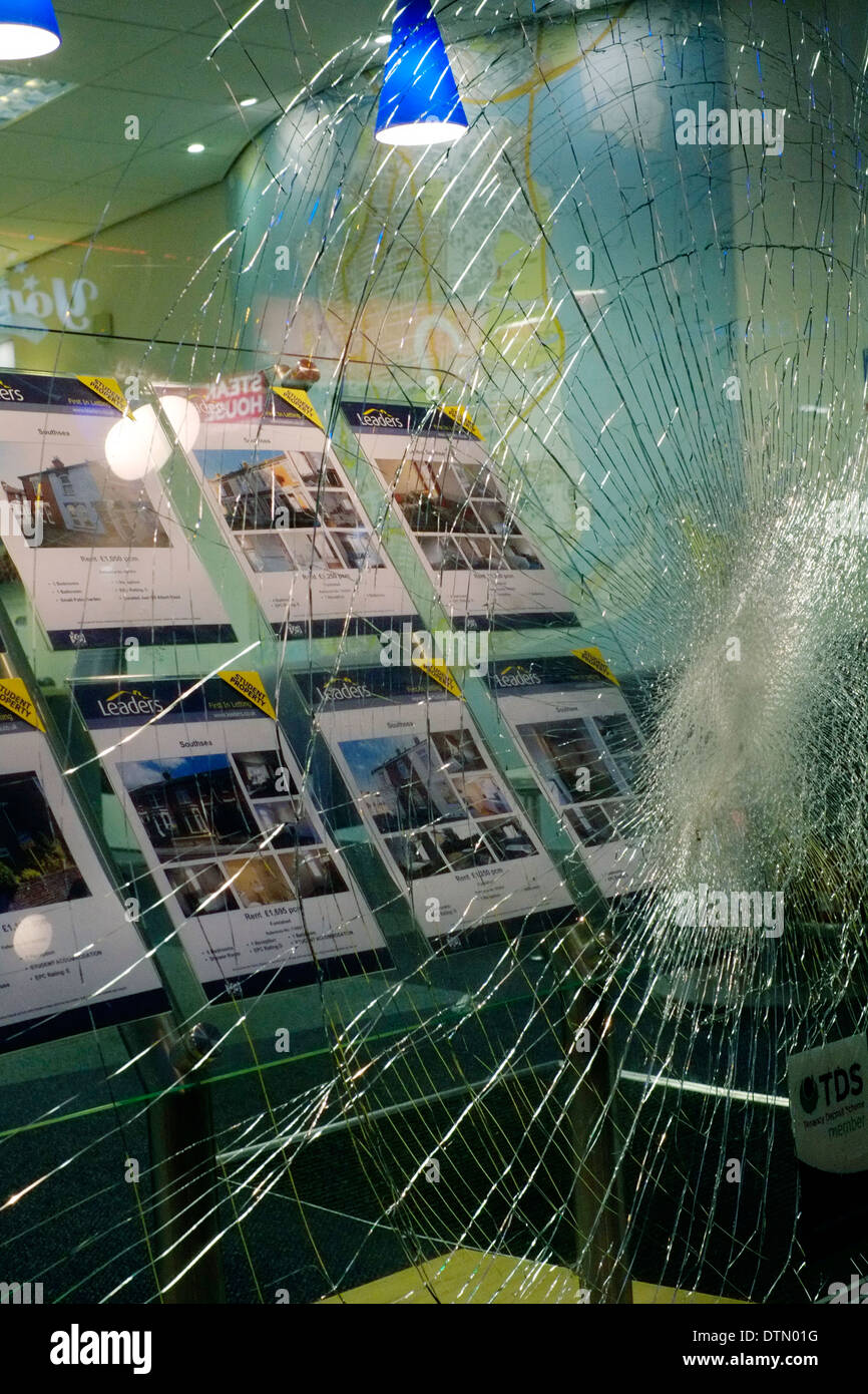 smashed glass window in an estate agents shop front Stock Photo - Alamy