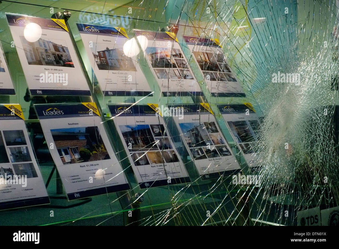 smashed glass window in an estate agents shop front Stock Photo - Alamy
