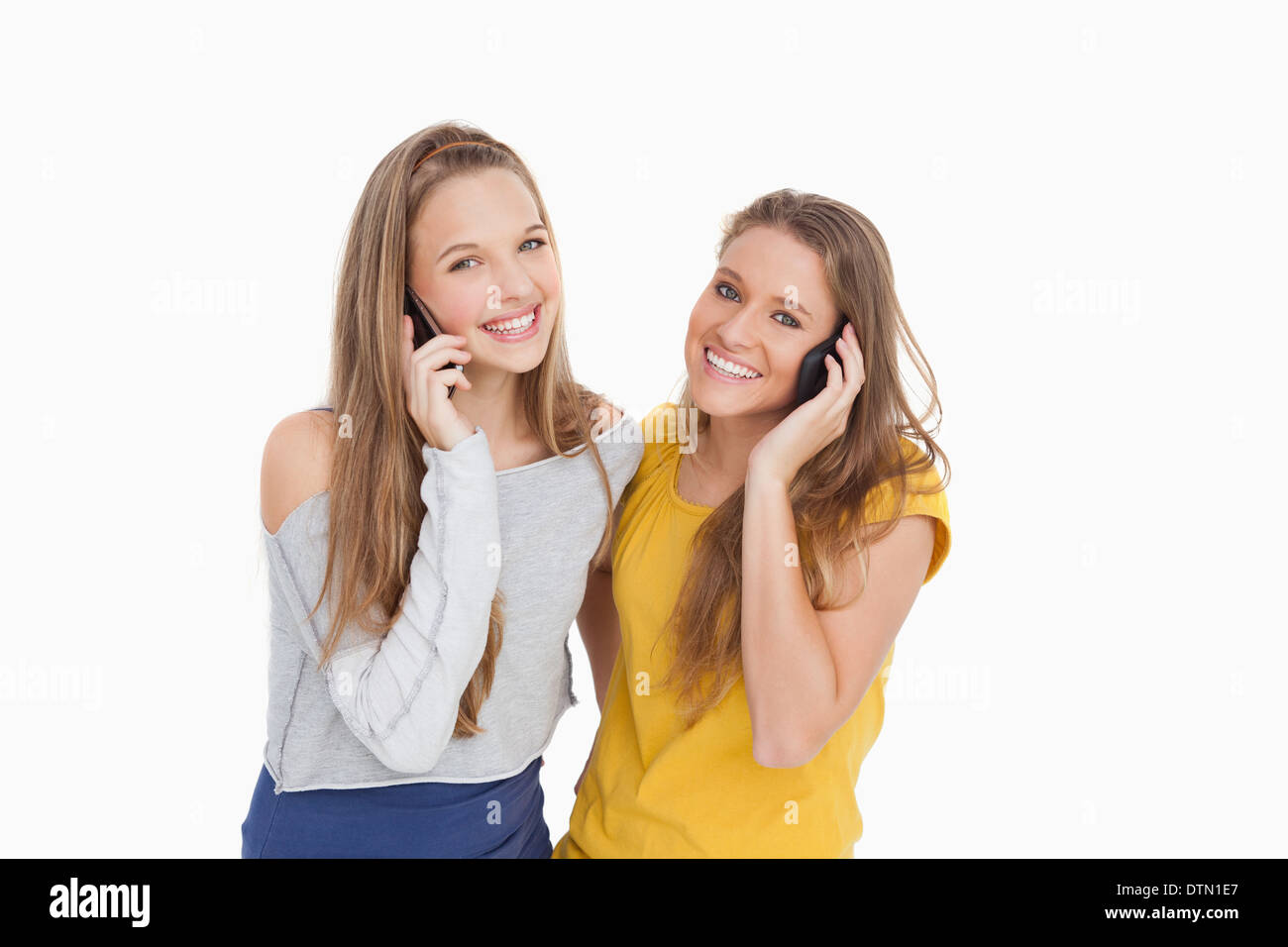 Two young women smiling on the phone Stock Photo - Alamy