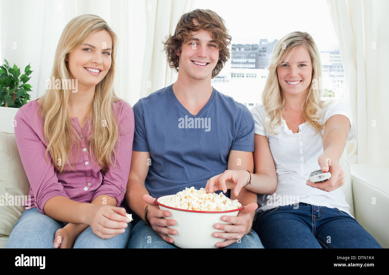 Three friends enjoying popcorn together Stock Photo - Alamy
