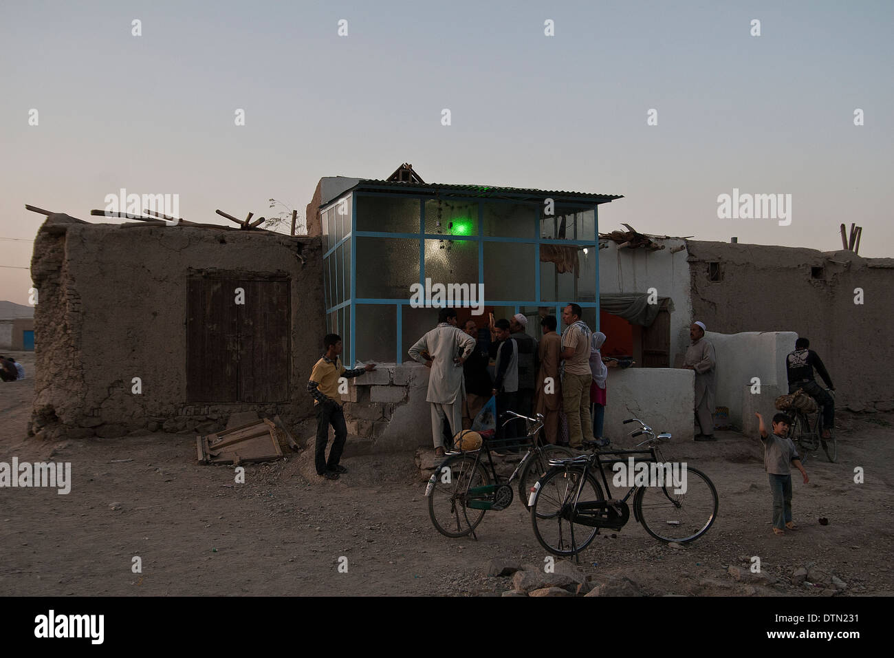 Afghans line up to buy bread from local bakery at dusk in Kabul suburb ...