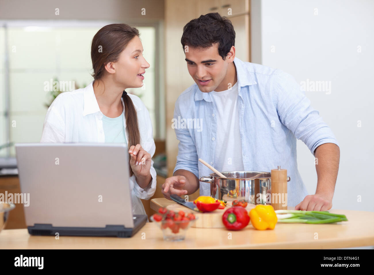 Couple using a notebook to cook Stock Photo - Alamy