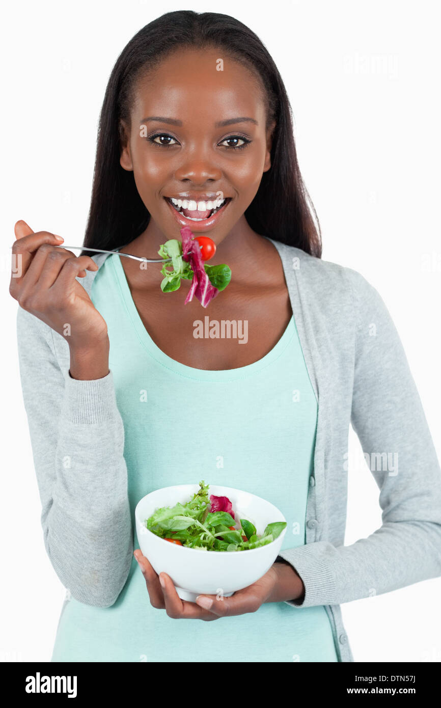 Smiling young woman eating salad Stock Photo - Alamy