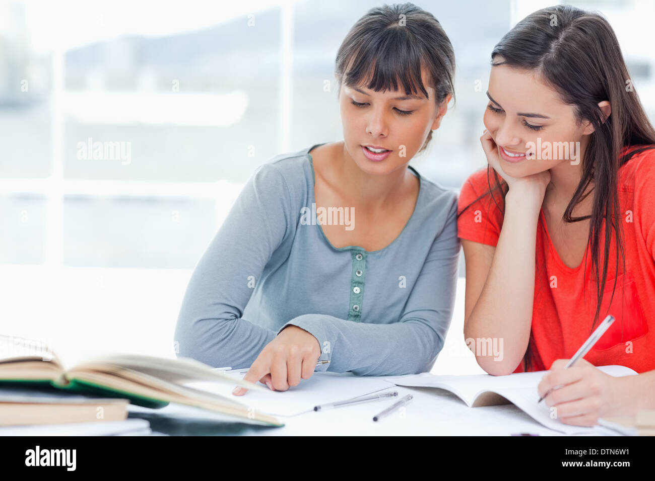Two girls help one another as they study Stock Photo - Alamy