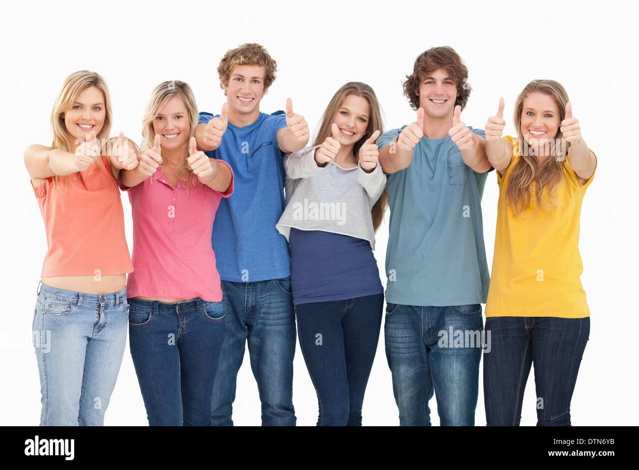 Six friends giving thumbs up as they smile Stock Photo - Alamy