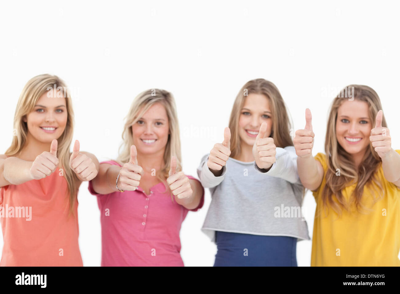 Four smiling girls giving the thumbs up Stock Photo - Alamy