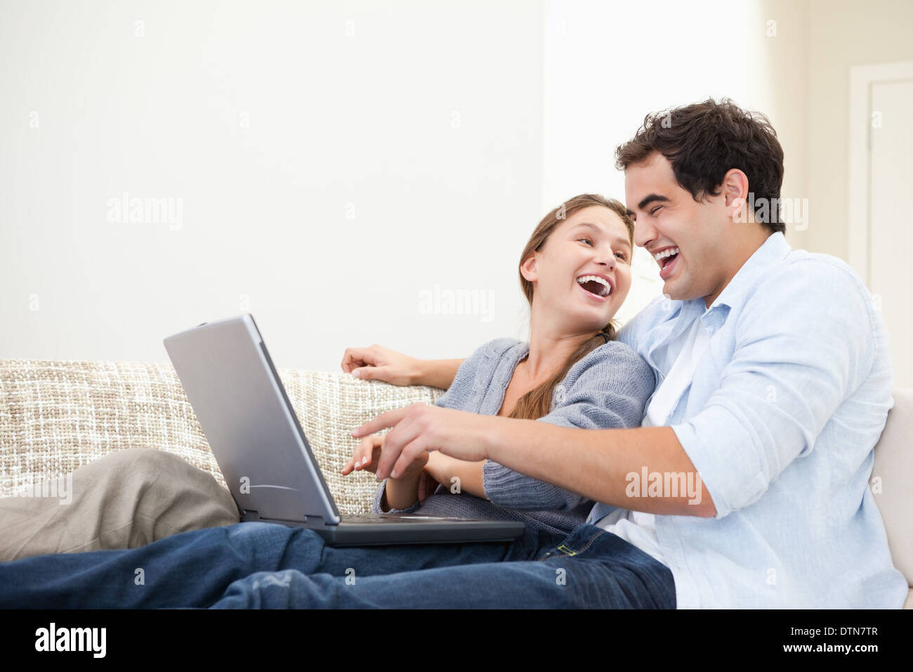 Couple laughing while typing on a computer Stock Photo - Alamy