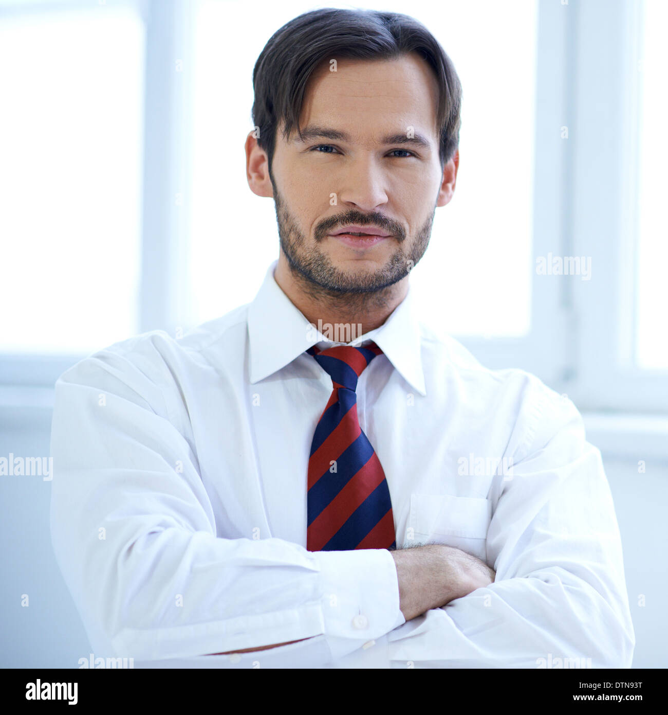 Handsome man standing with folded arms Stock Photo - Alamy