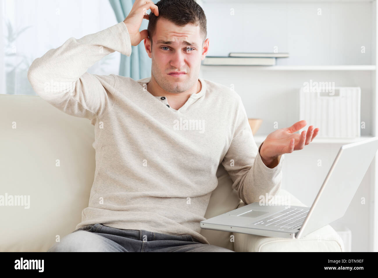 Confused young man using laptop hi-res stock photography and images - Alamy