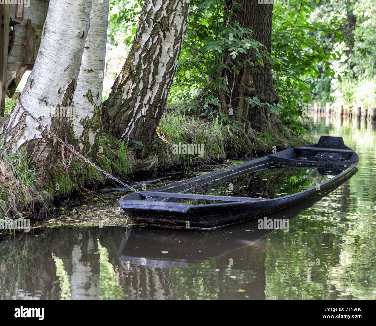 Sinking water-filled punt moored on an irrigation canal in the ...
