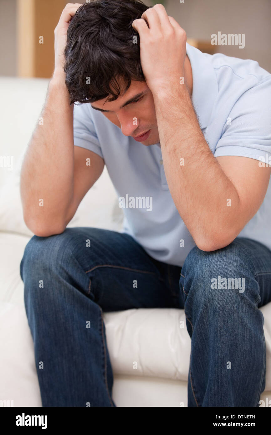 Frustrated man sitting on the couch Stock Photo - Alamy