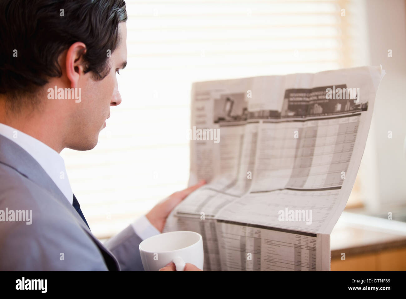 Side view of businessman reading newspaper Stock Photo - Alamy