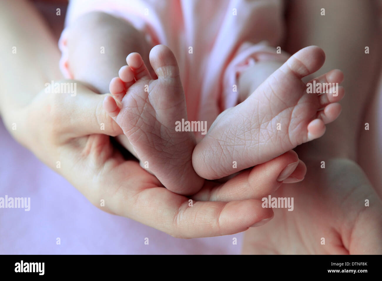 Parent hand hold baby girl legs Stock Photo - Alamy