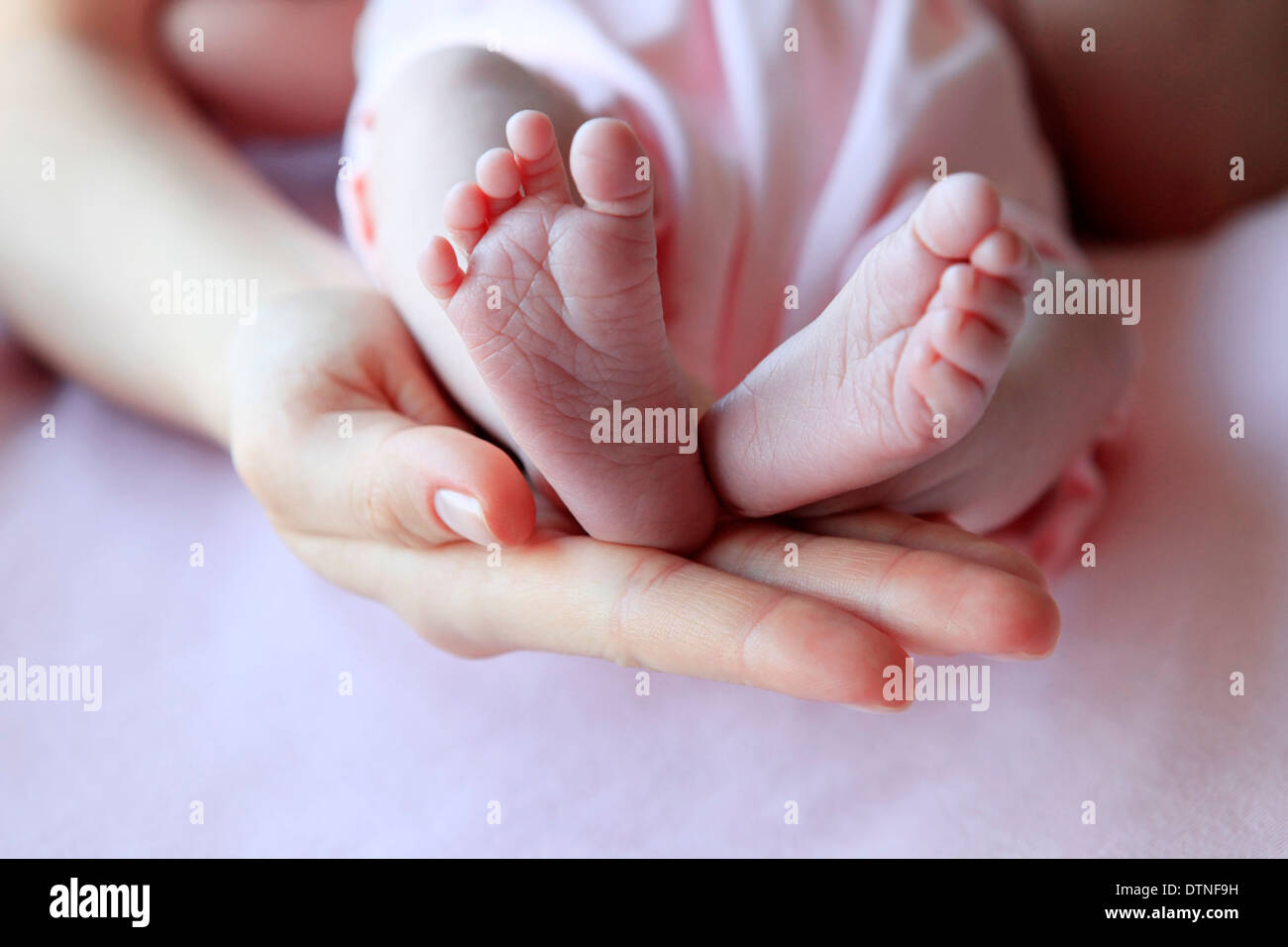 Parent hand hold baby girl legs Stock Photo - Alamy
