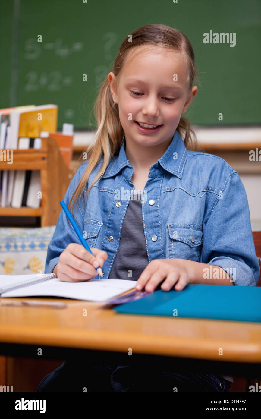 Portrait of a happy schoolgirl writing Stock Photo - Alamy