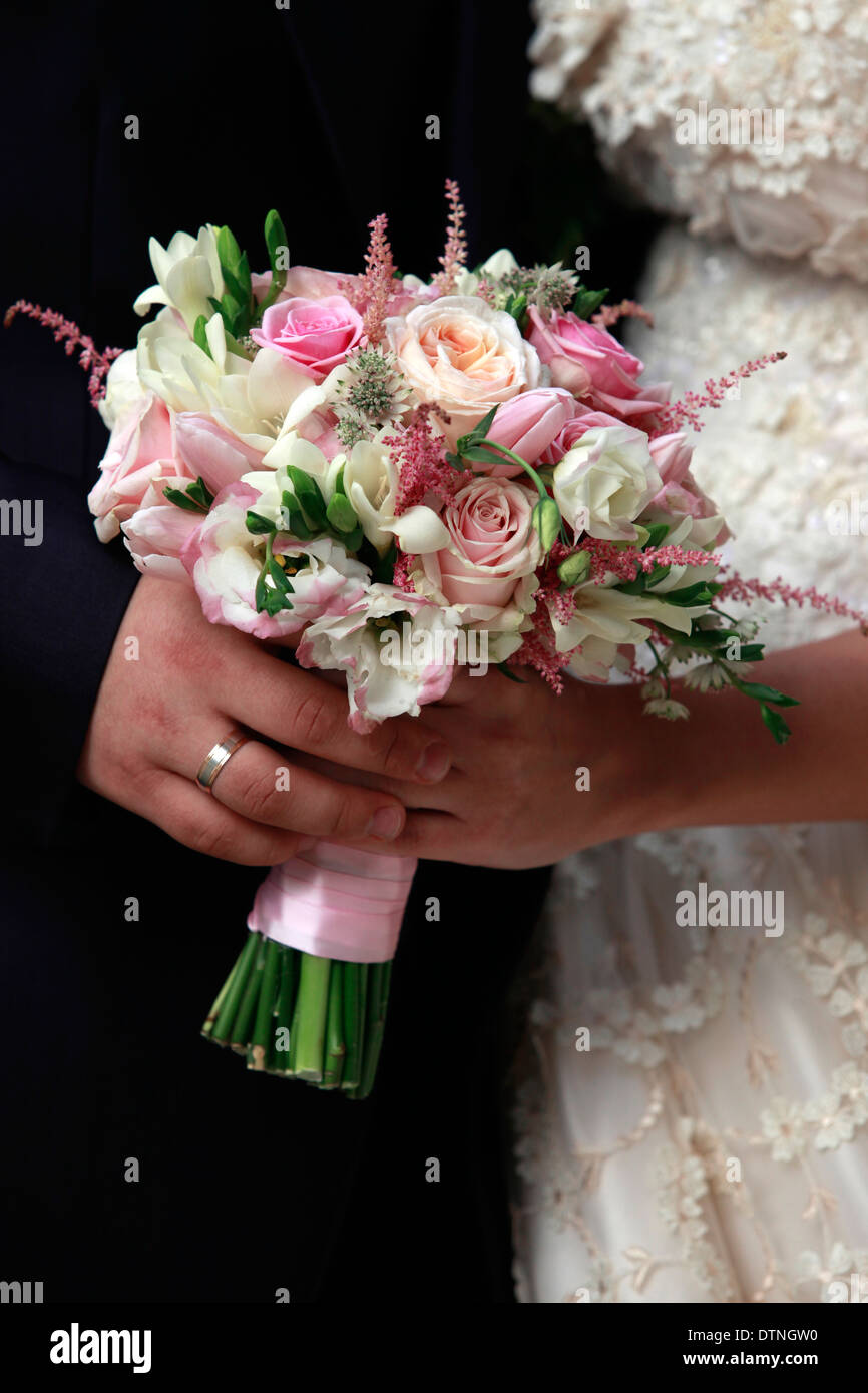 Newly-married couple with bouquet from pink roses Stock Photo - Alamy