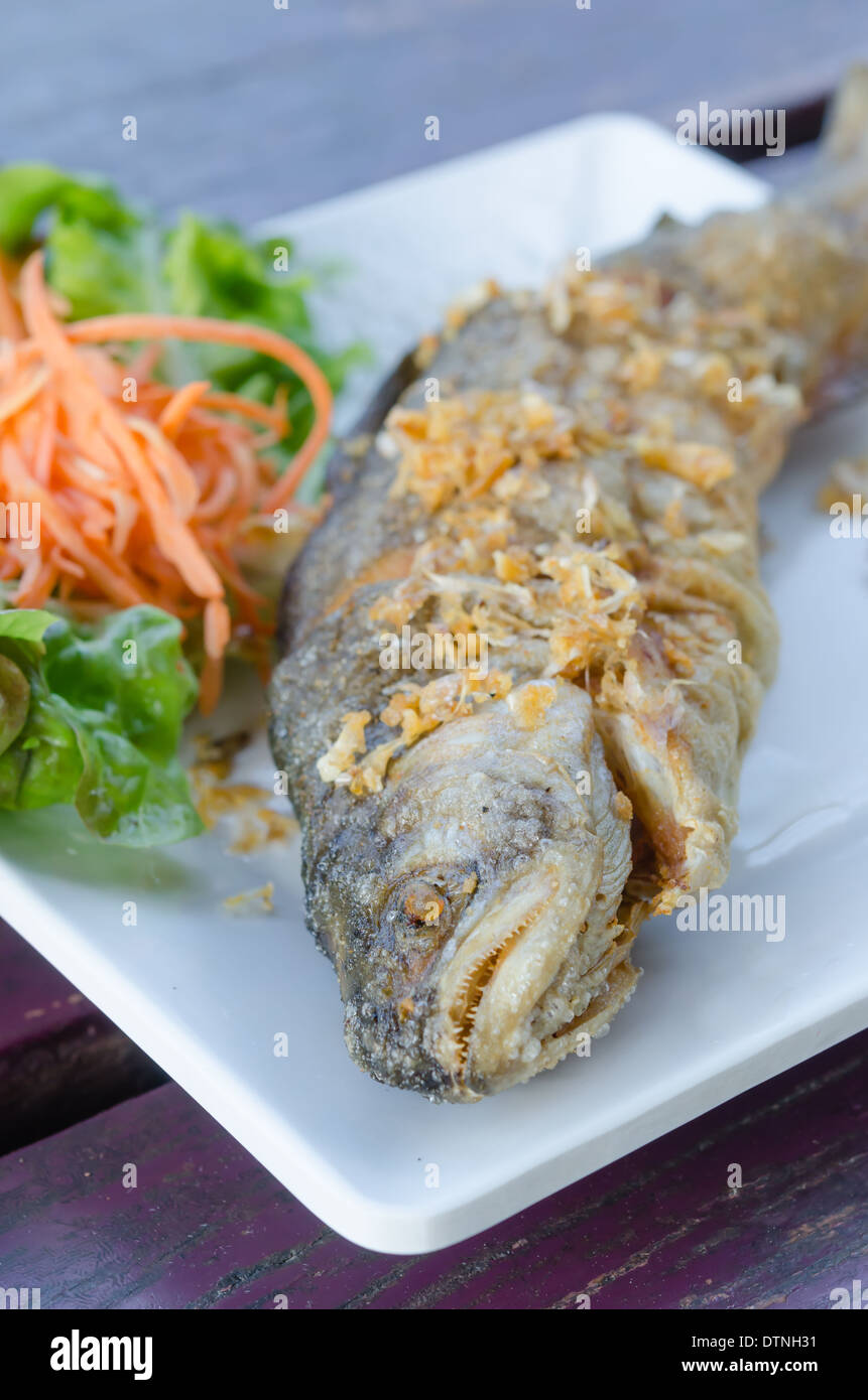 fried fish and garlic served with fresh vegetable Stock Photo - Alamy