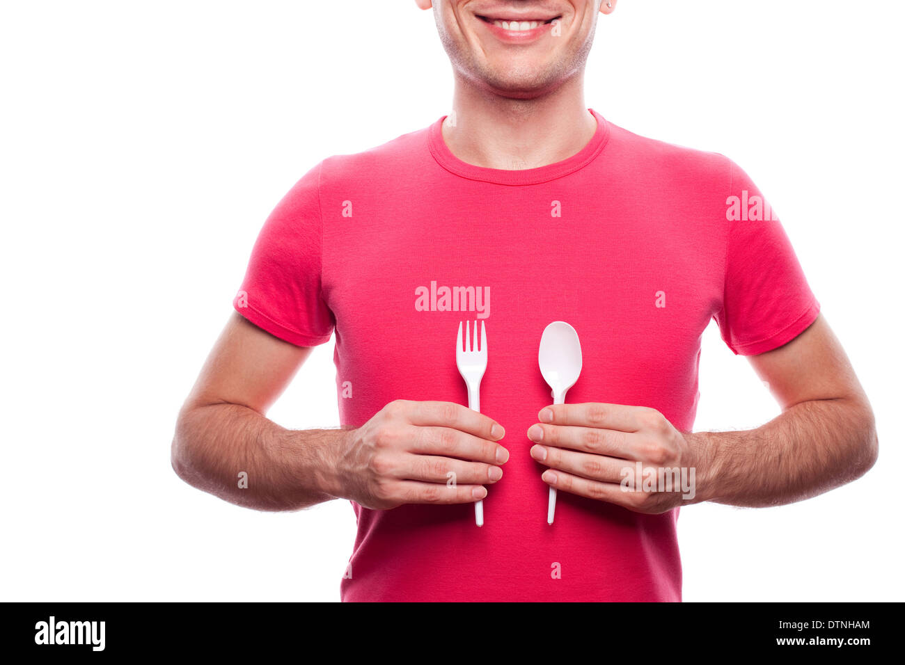 smiling handsome guy holding plastic fork and spoon near his stomach ...