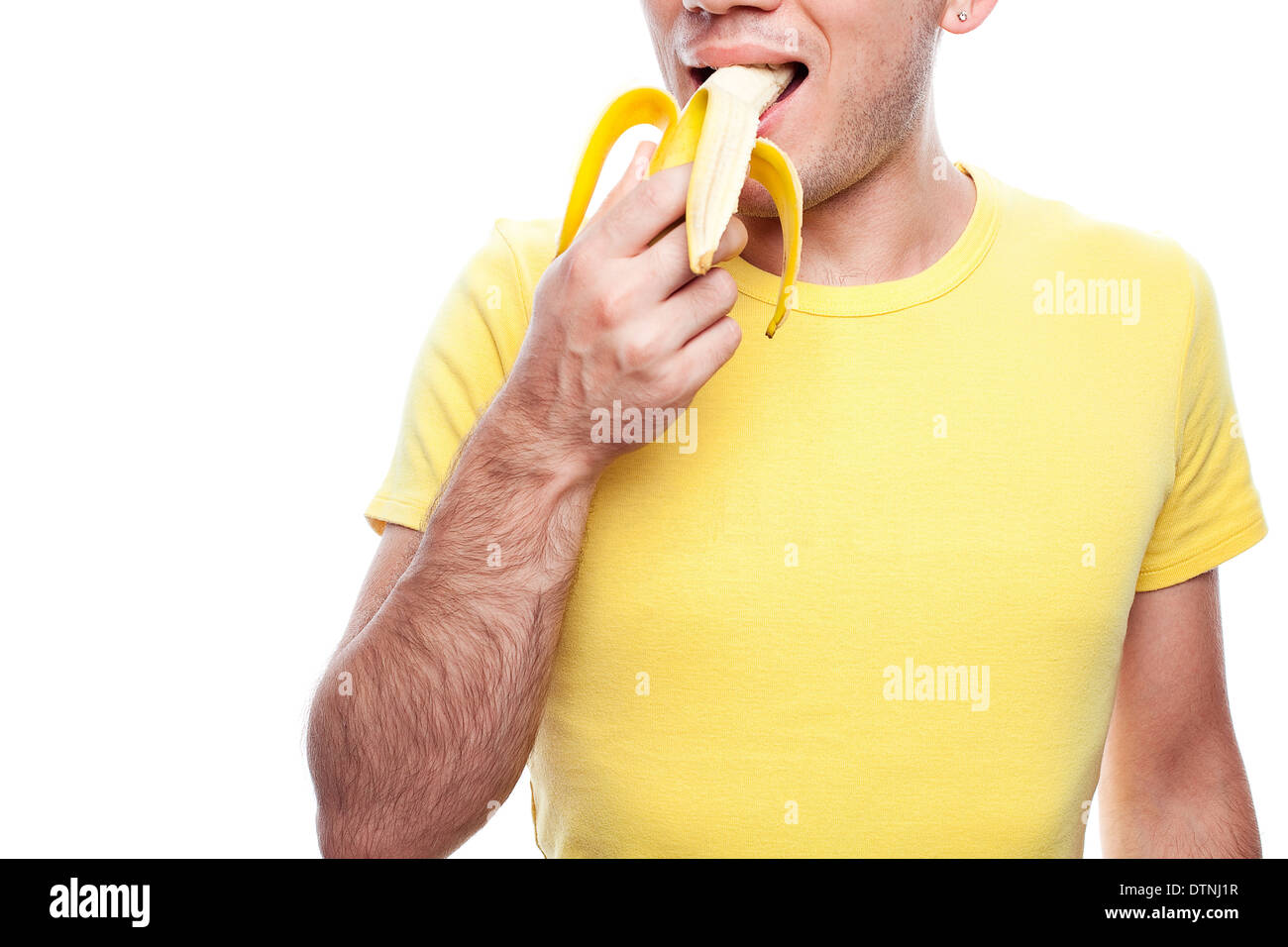smiling handsome guy holding and biting (eating) yellow banana over ...