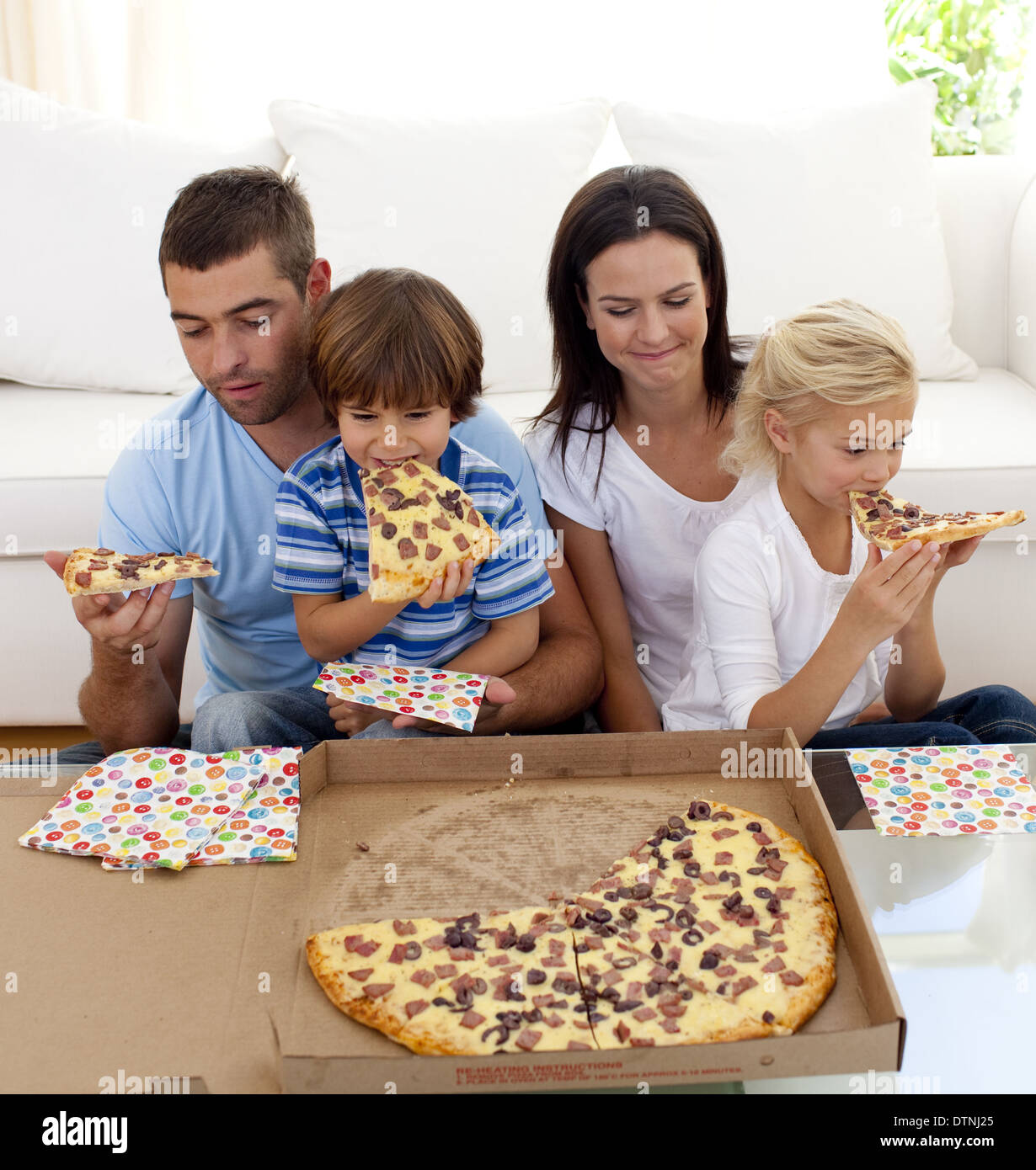 Family eating pizza in living room hi-res stock photography and images ...