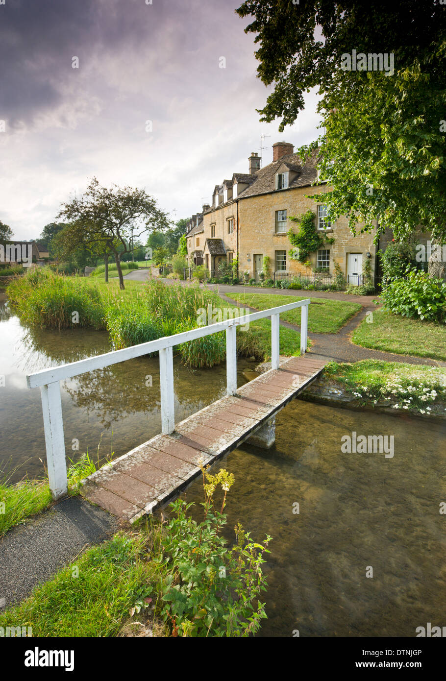 Cottages and footbridge over the River Eye in the Cotswolds village of ...