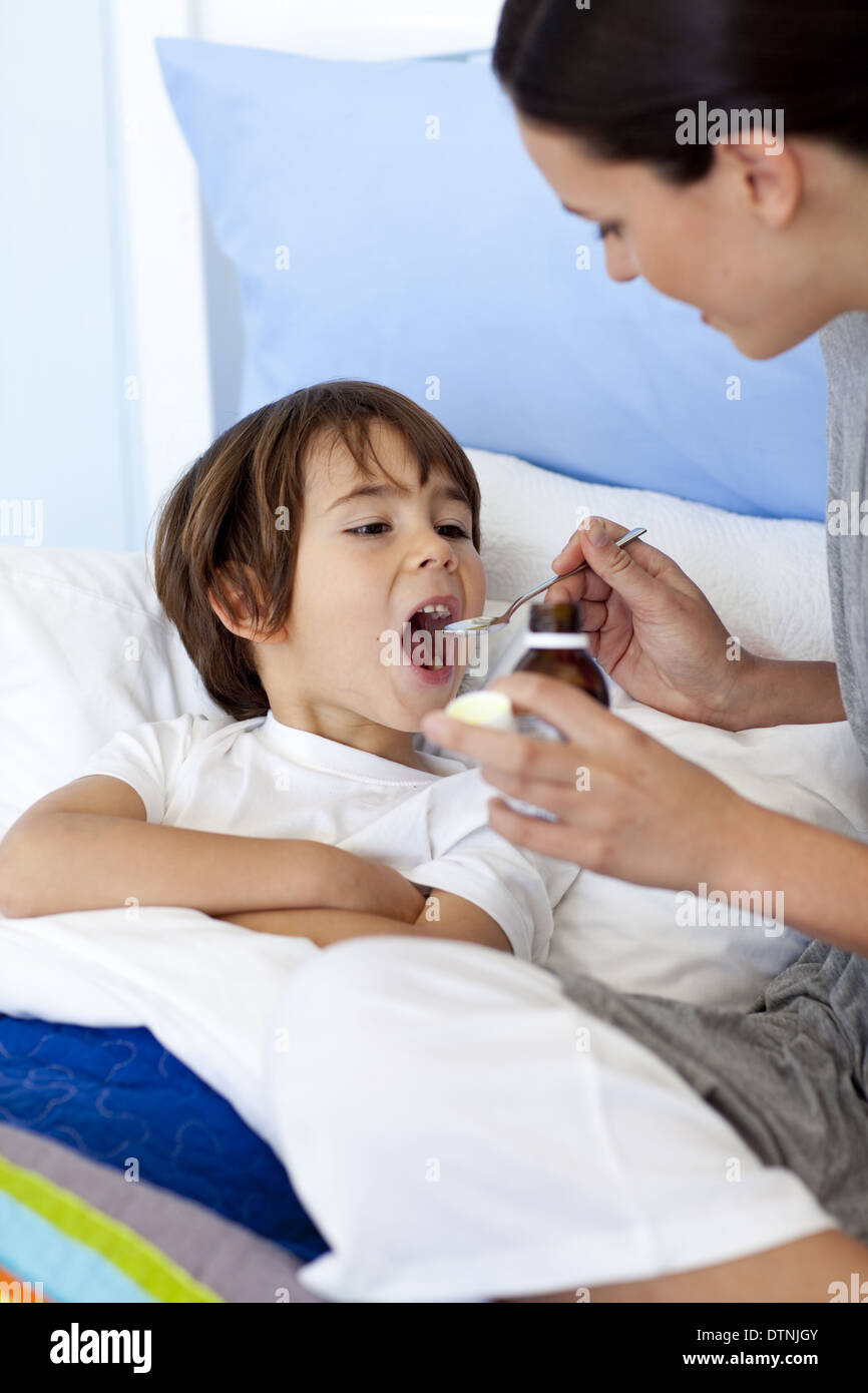 Mother giving her son syrup Stock Photo - Alamy