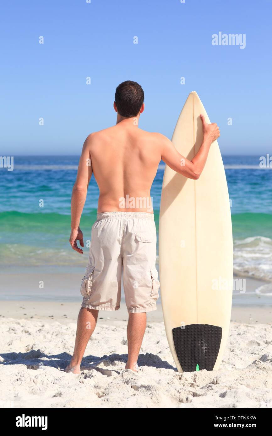 Man wirth his surfboard on the beach Stock Photo - Alamy