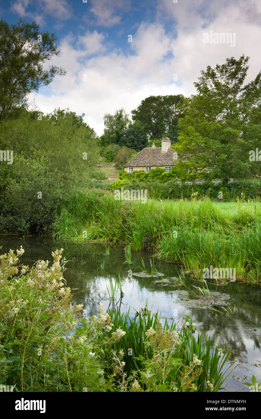 River Leach and rural cottage in the Cotswolds village of Eastleach ...