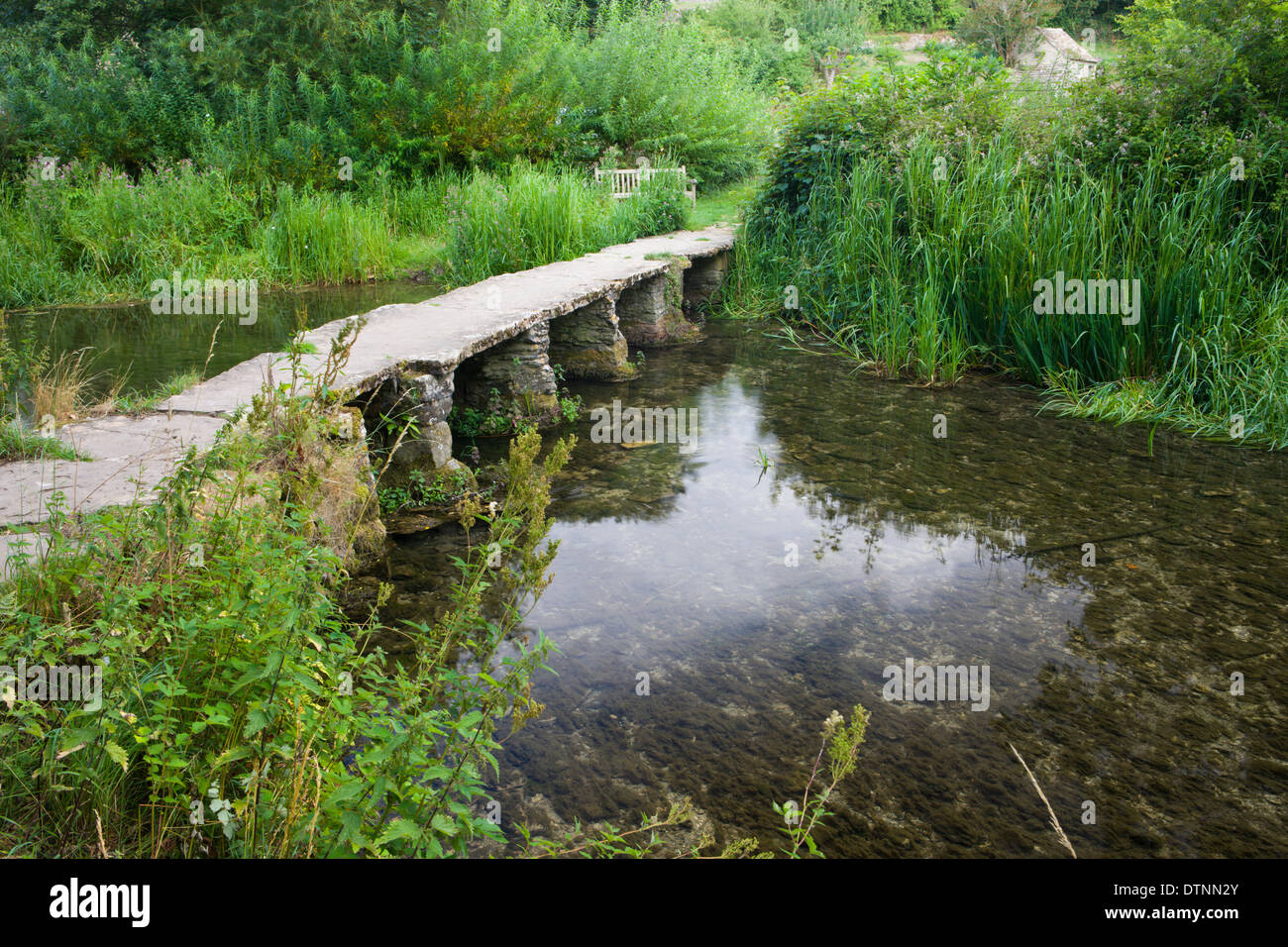 Clapper bridge crossing the River Leach in the pretty Cotswolds village ...
