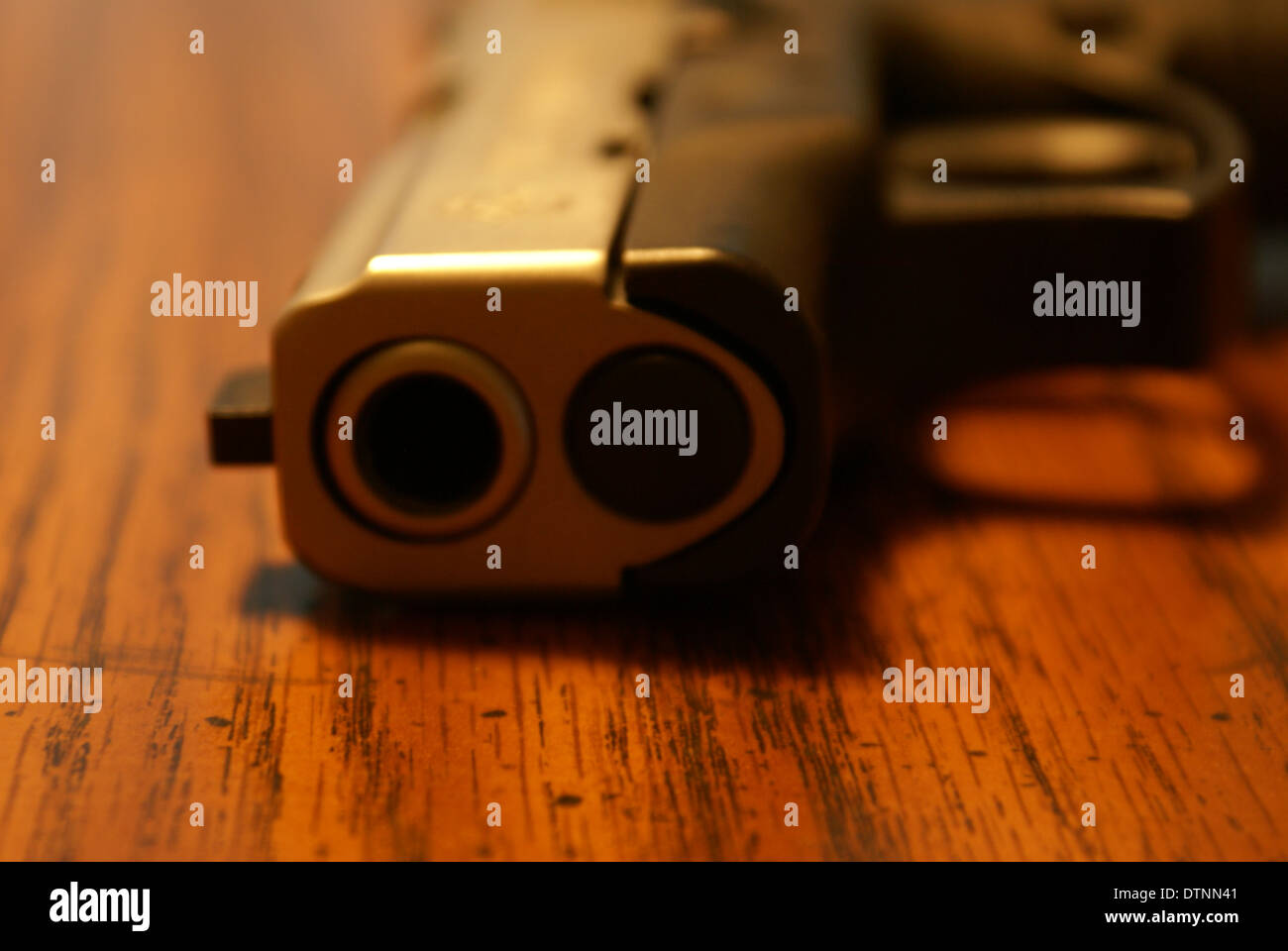 Photo of a muzzle of a handgun laying on an oak table Stock Photo - Alamy