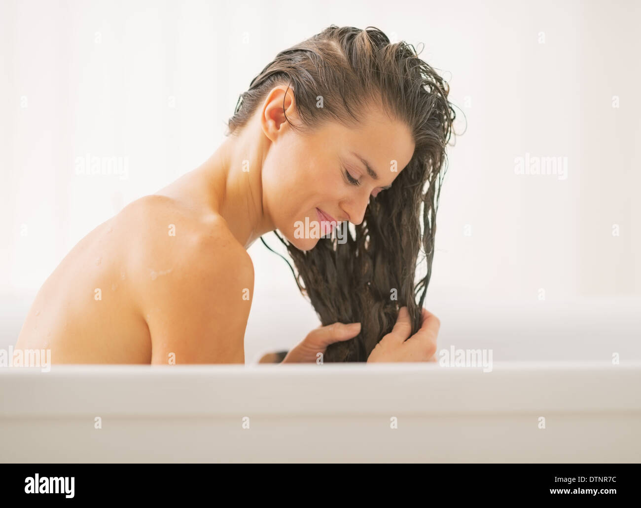 Happy young woman washing hair in bathtub Stock Photo - Alamy