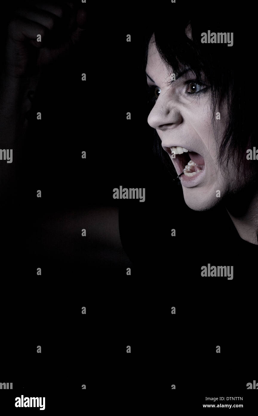 man screaming with anger, a moody portrait concept taken against black ...