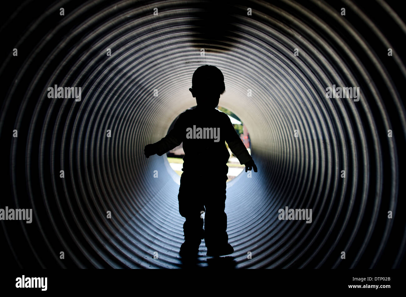 Small child walking in a tunnel in shadow Stock Photo - Alamy