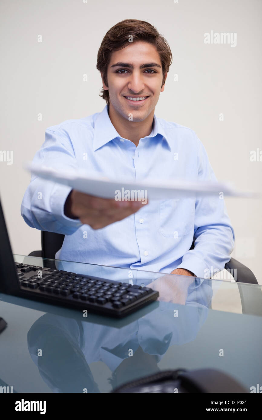 Smiling businessman handing over paperwork Stock Photo - Alamy