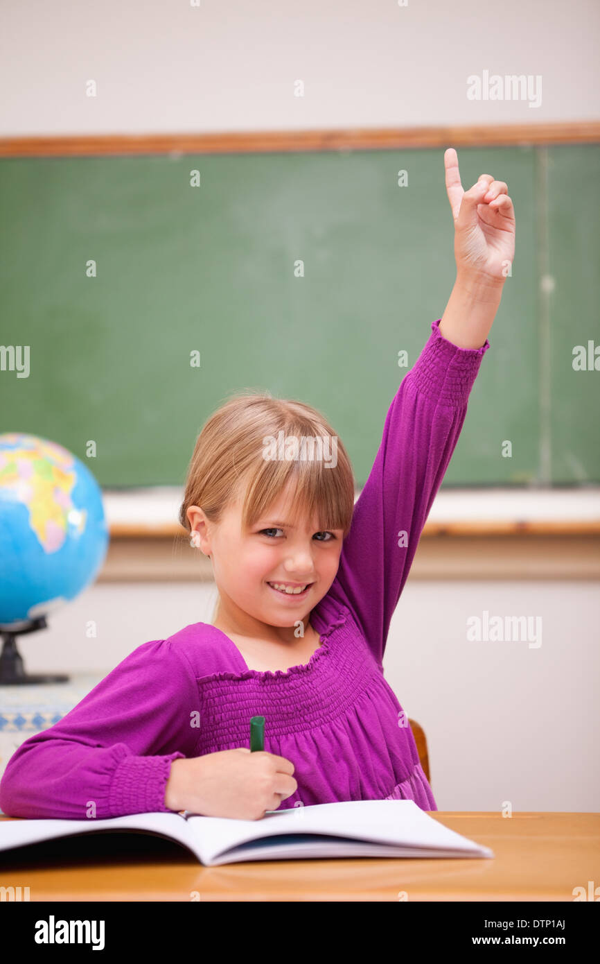 Portrait of a schoolgirl raising her hand Stock Photo - Alamy
