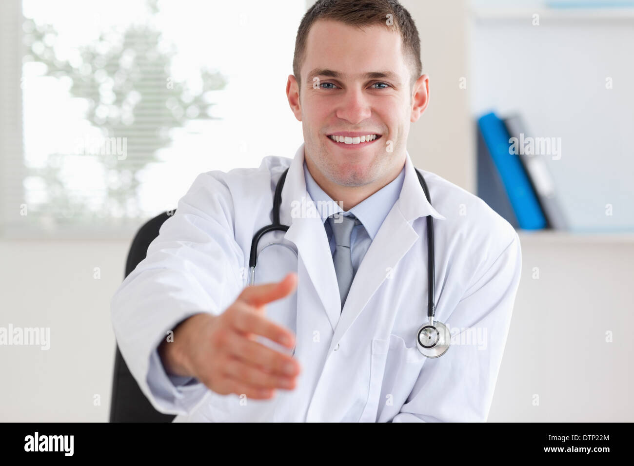 Doctor welcoming patient Stock Photo - Alamy
