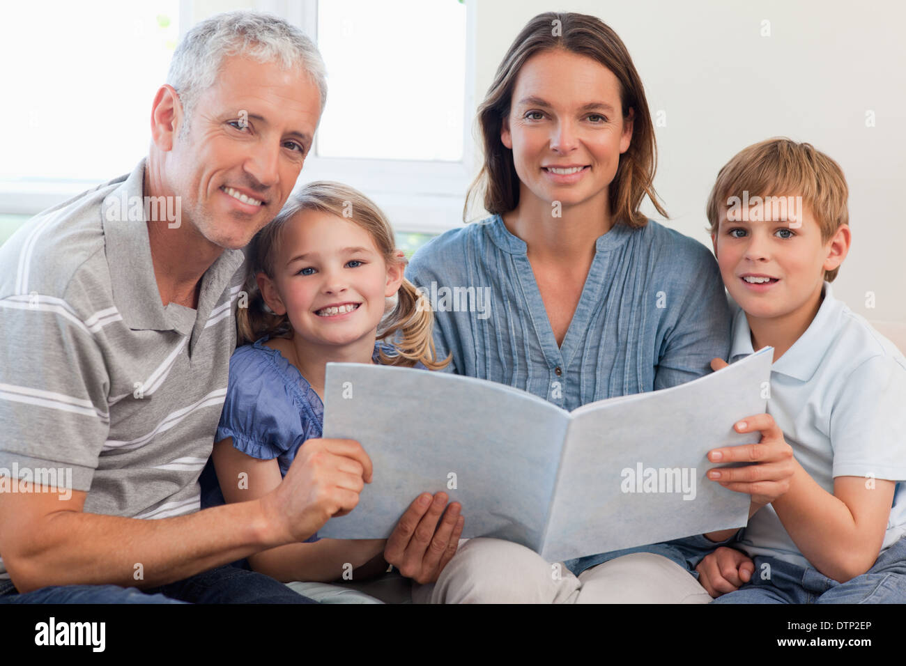 Happy family reading a book together Stock Photo - Alamy