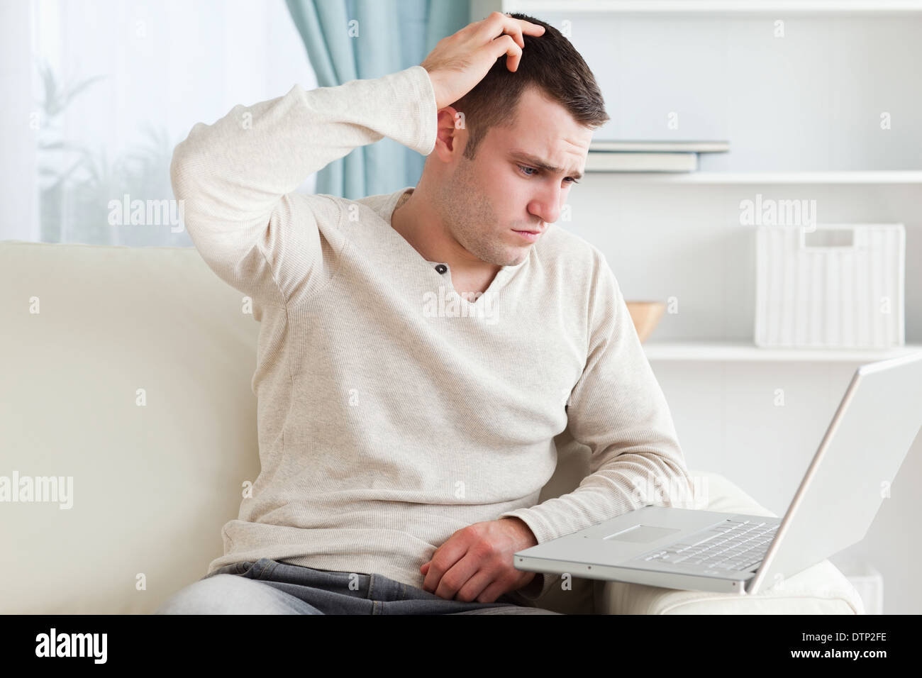Confused man using a notebook Stock Photo - Alamy