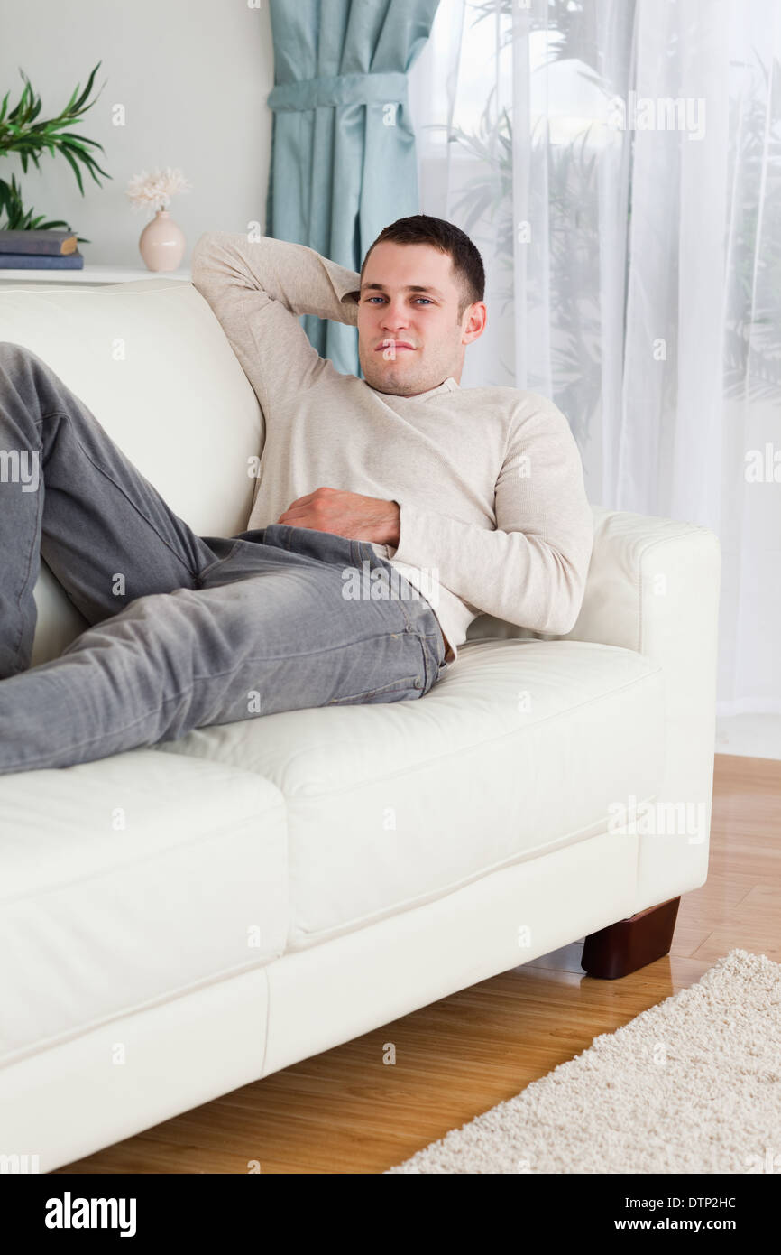 Portrait of a man lying on a sofa Stock Photo - Alamy