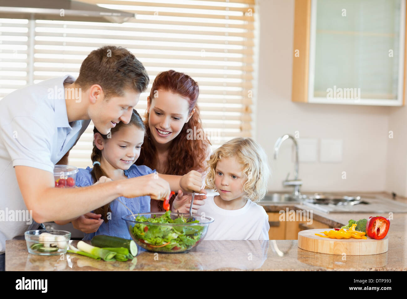 Family preparing salad together Stock Photo - Alamy
