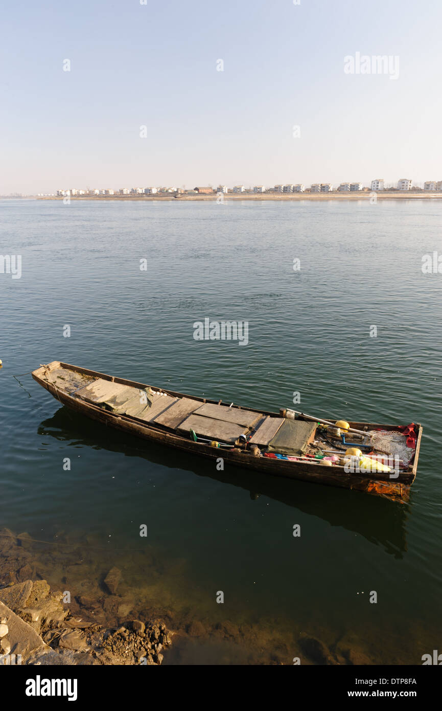 Moored fishing boat on the Chinese side of the Yalu river. North Korea ...