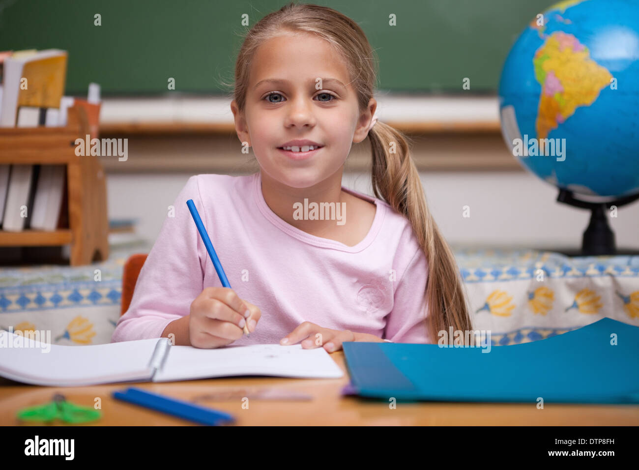 Smiling schoolgirl writing Stock Photo - Alamy