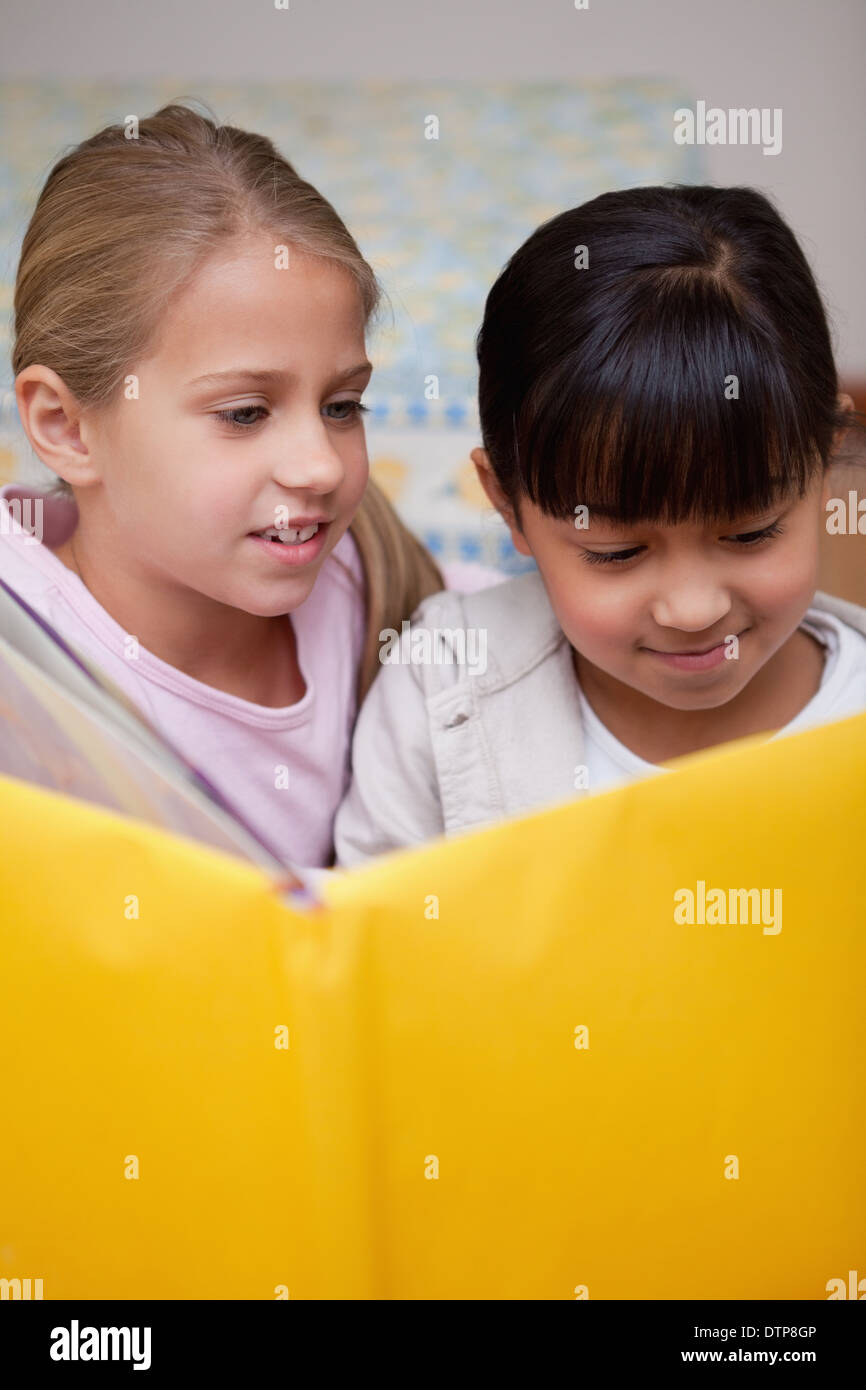 Portrait of cute schoolgirls reading Stock Photo - Alamy