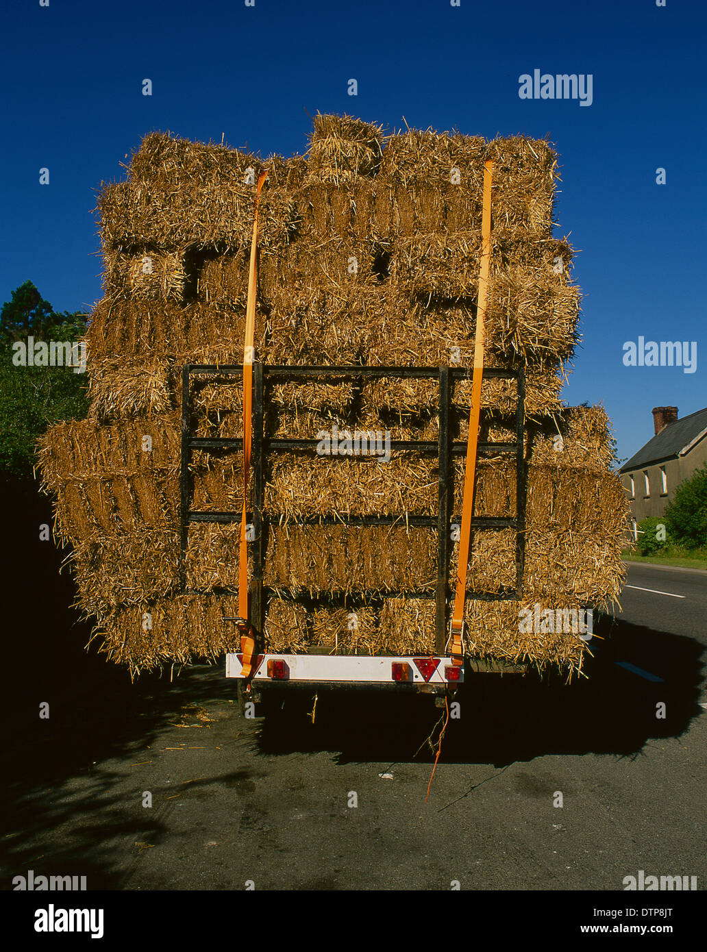 badly loaded hay trailer uneven load Stock Photo - Alamy