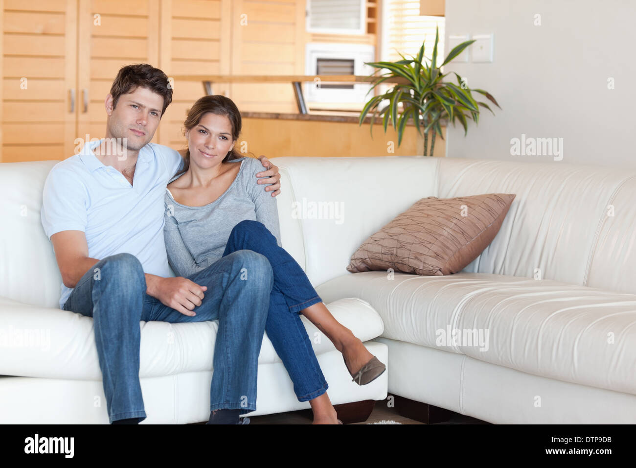 Couple sitting on a couch Stock Photo - Alamy