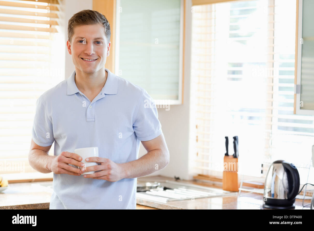 Man with cup in the kitchen Stock Photo - Alamy