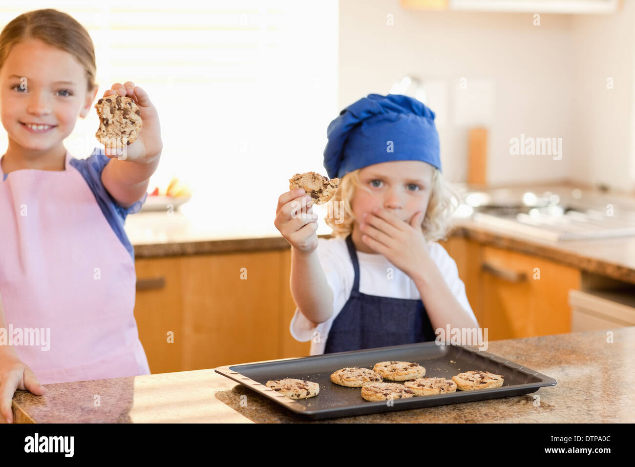Siblings showing their cookies Stock Photo - Alamy