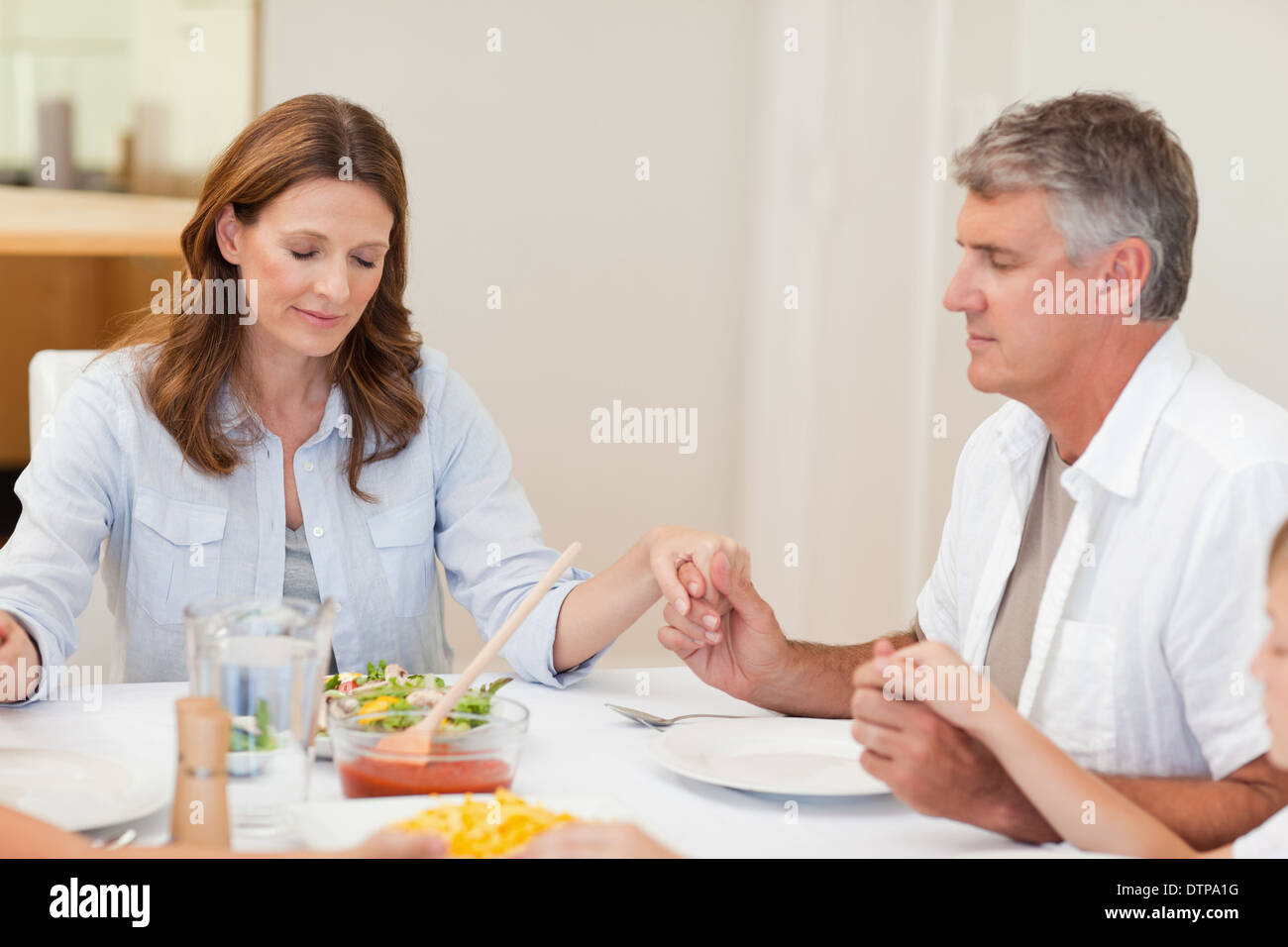 Family praying before dinner Stock Photo - Alamy