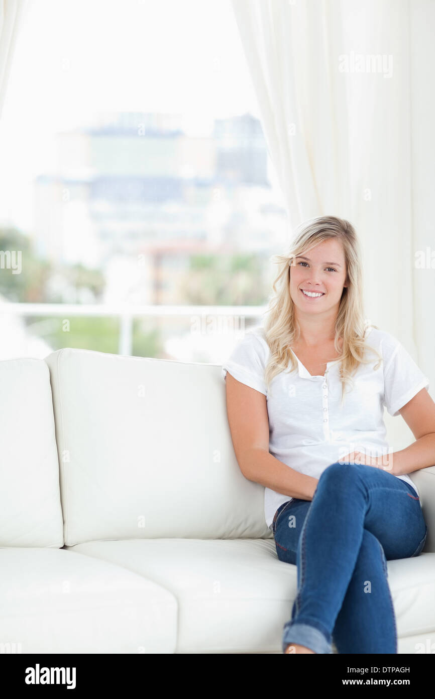 A smiling woman with her legs crossed Stock Photo - Alamy